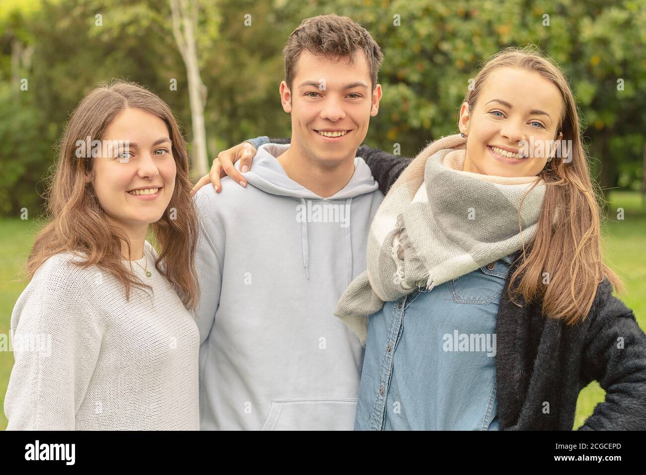 Christian friendship. Three happy friends laughing and hugging outdoors ...