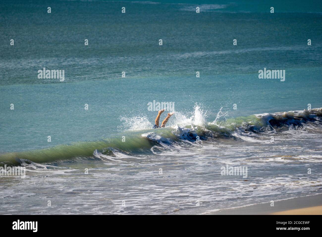 Legs of a man jumping into the aquamarine bright foamy ocean Stock ...