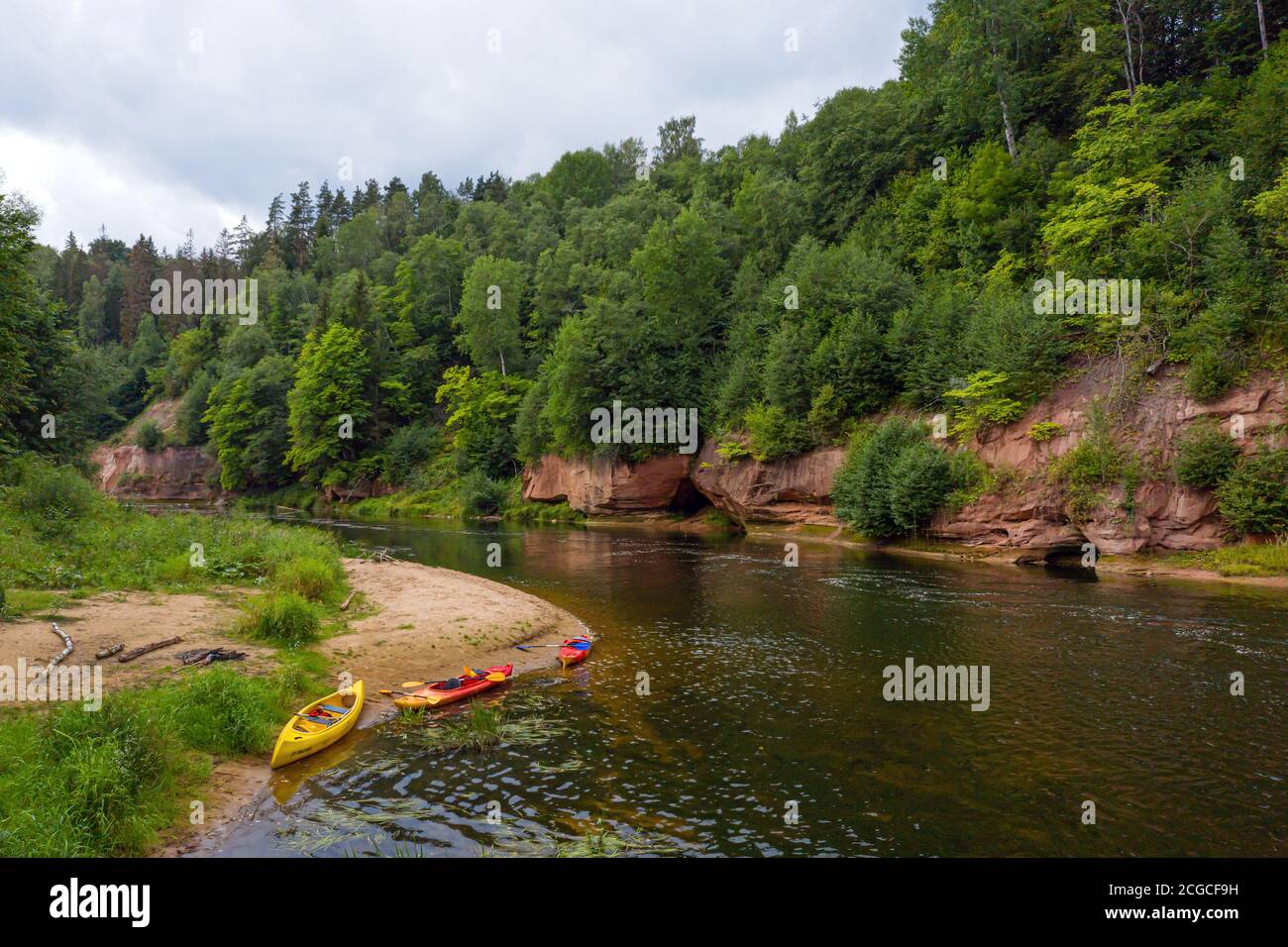 landscape with sandstone cliffs, canoes and kayaks on the Gauja river ...