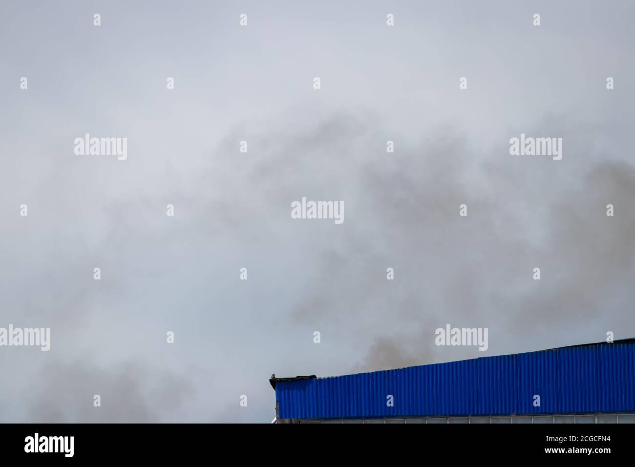 Black smoke rising from a burning building with a cloudy sky Stock ...