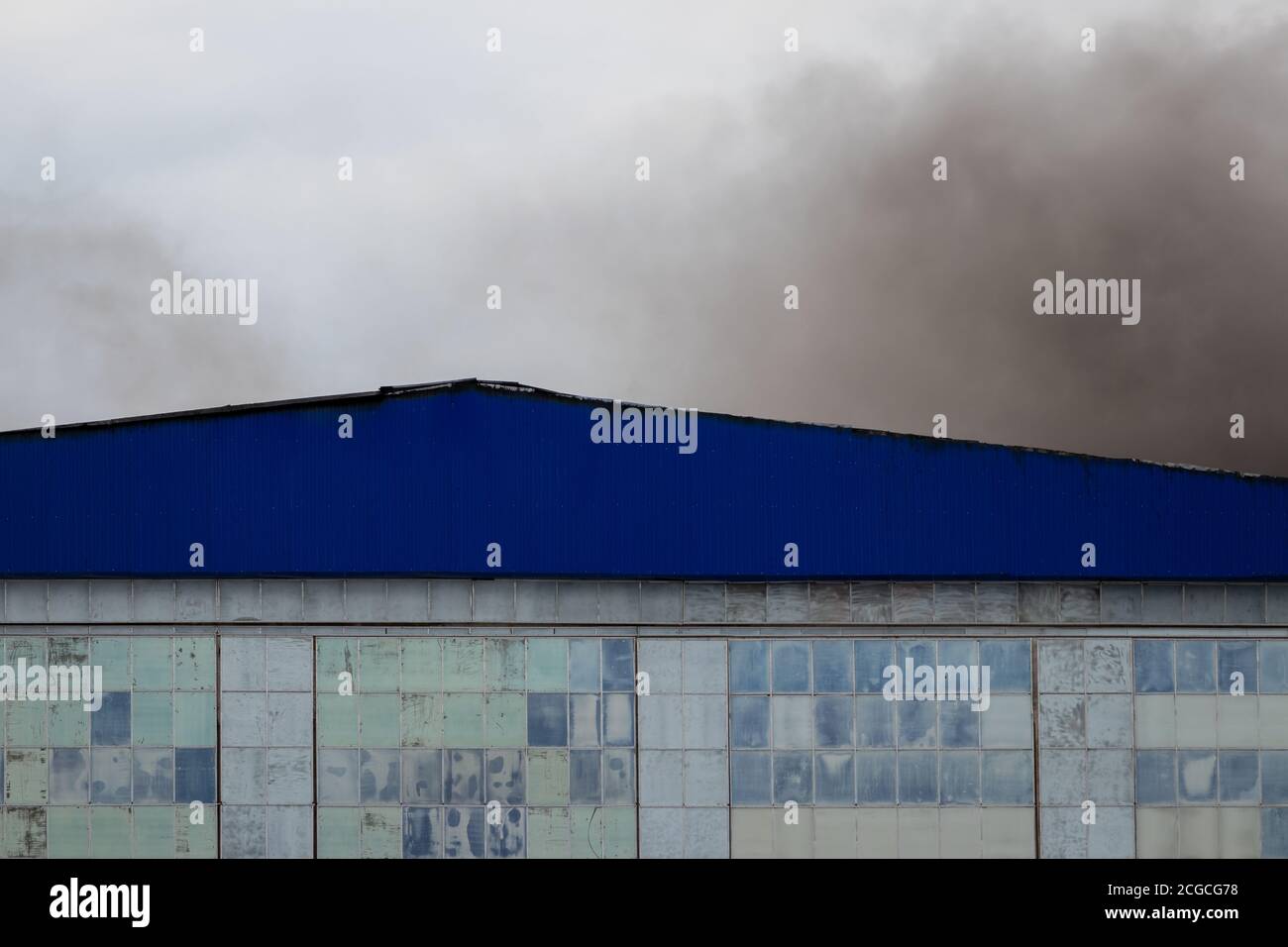 Black smoke rising from a burning building with a cloudy sky Stock ...