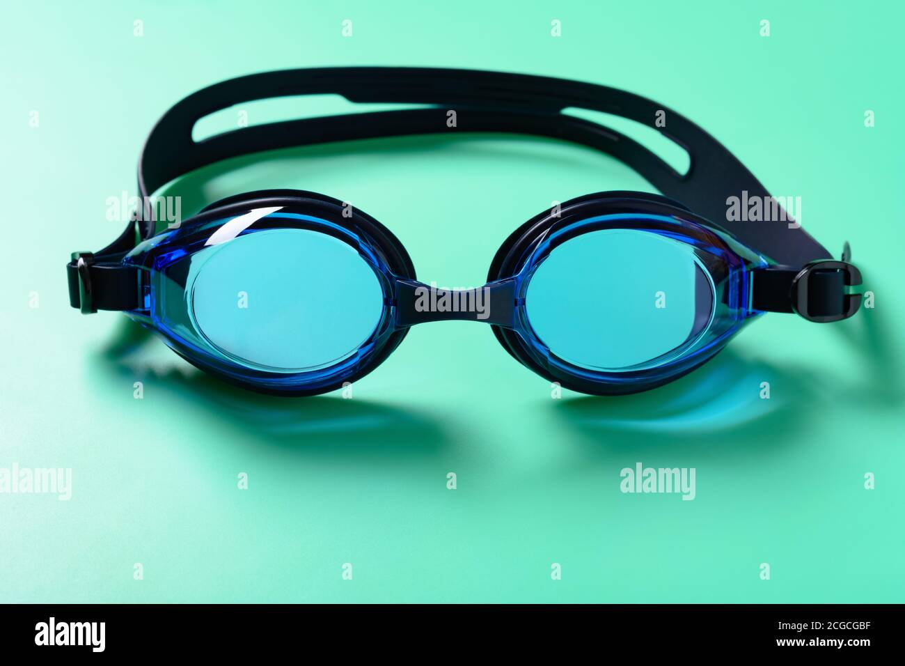 front view blue swimming goggles on a green background Stock Photo - Alamy