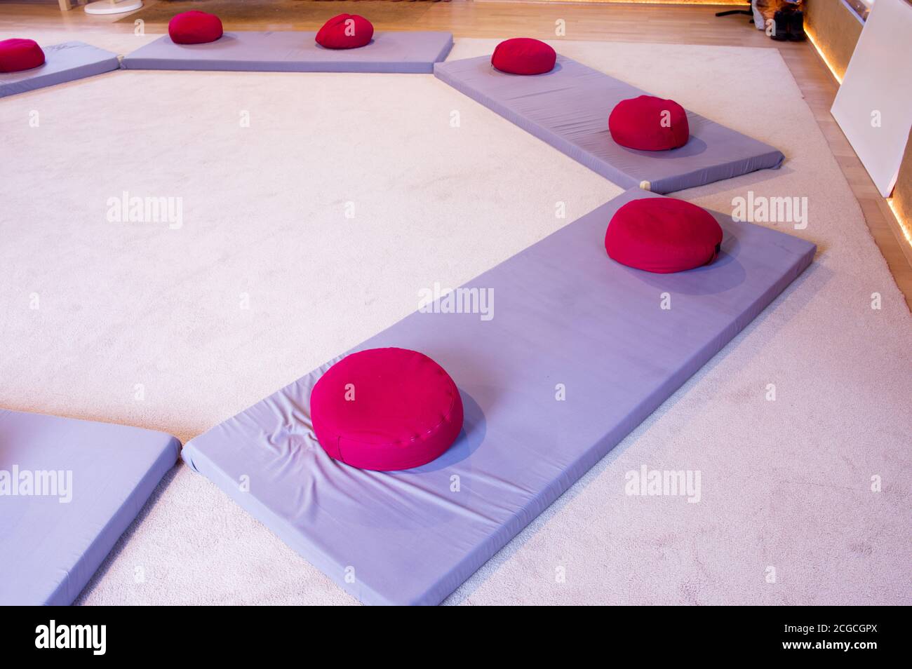 Circle of red meditation cushions on grey mattresses Stock Photo - Alamy