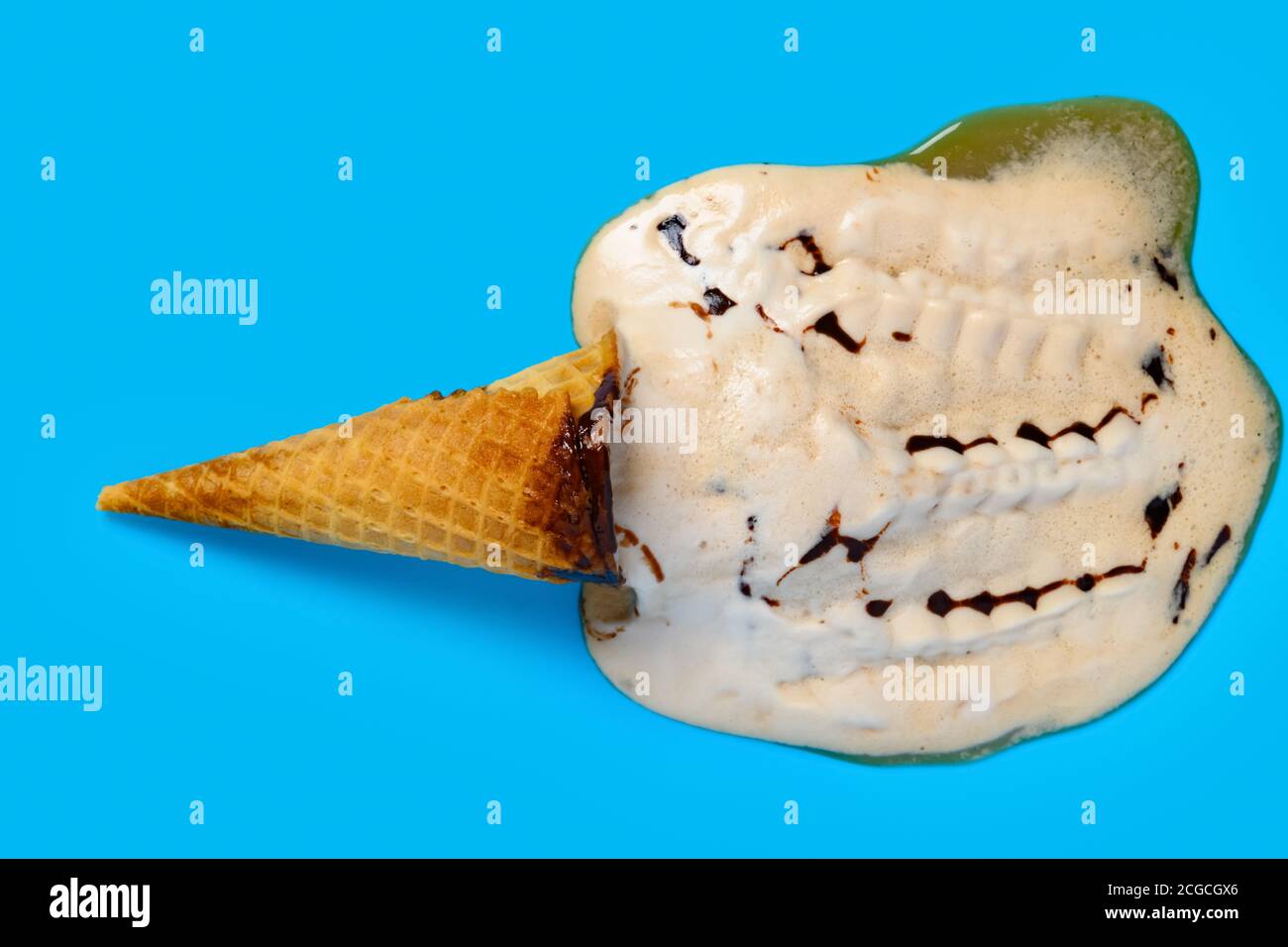 top view milk tea flavor ice cream cone melting on blue background ...