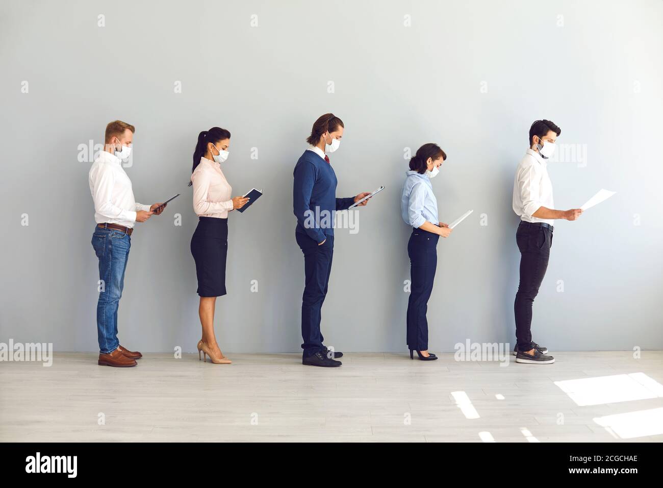 Group of business people in masks standing with documents in line and ...