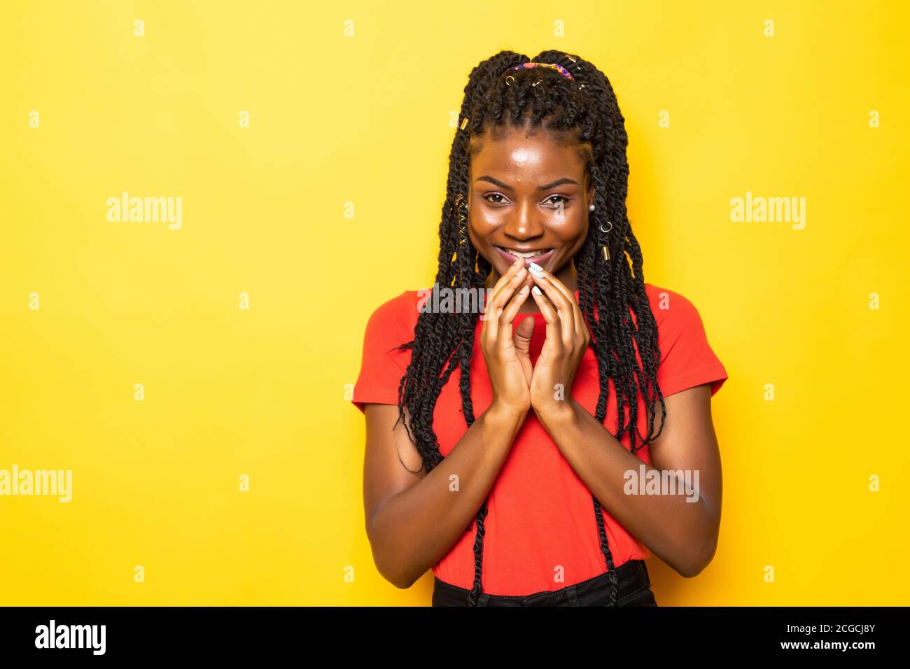 Beautiful african woman arms touch cheekbones look wondered empty space ...