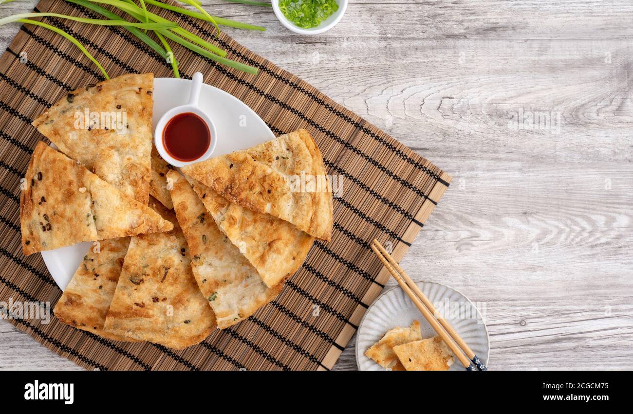 Taiwanese food - delicious flaky scallion pie pancakes on bright wooden ...