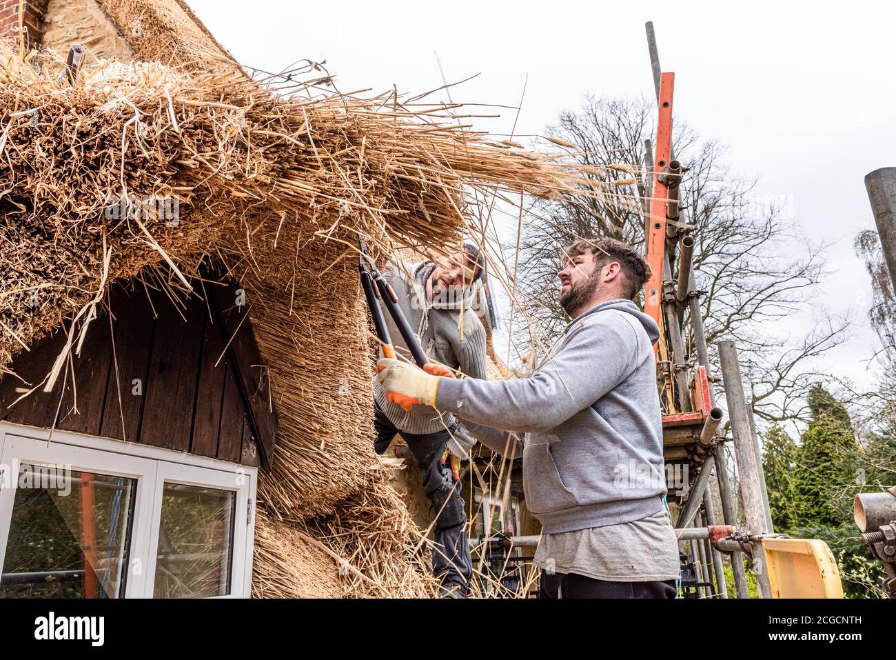 workmen thatching the roof of an old cottage Stock Photo - Alamy
