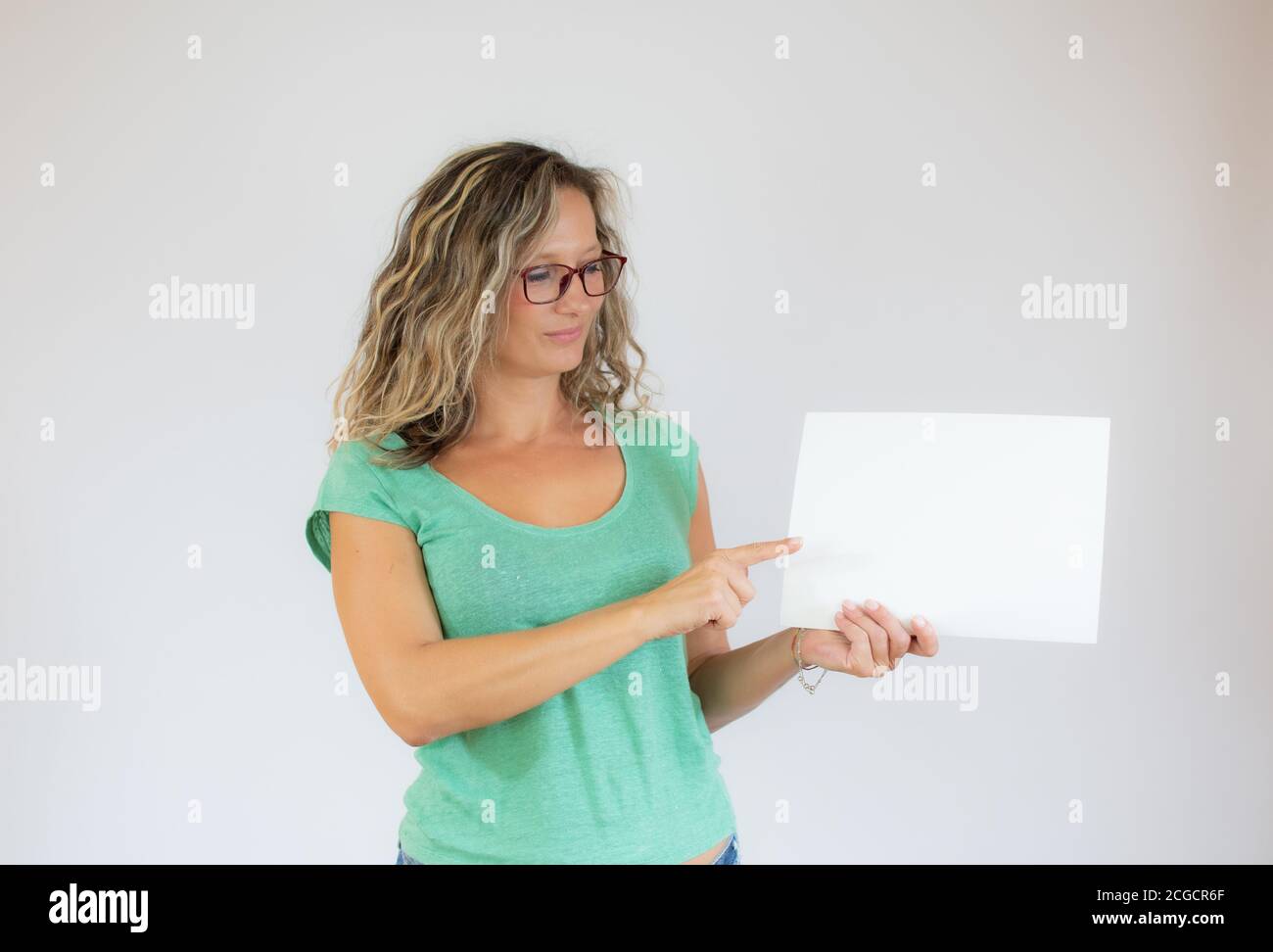Beautiful woman with glasses pointing to a paper Stock Photo - Alamy