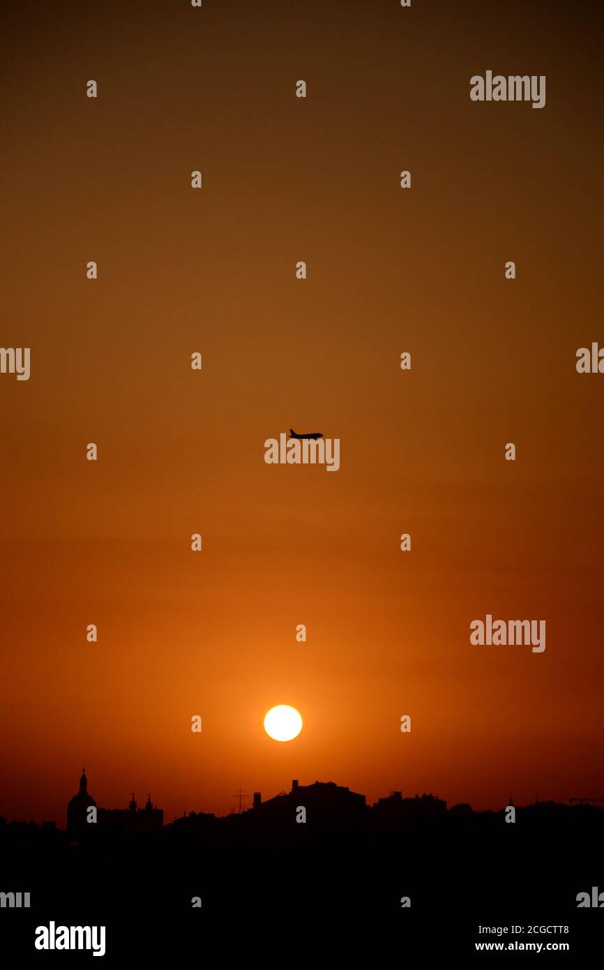 The sun forms a perfect sphere, casting a warm glow over the scene. A ...