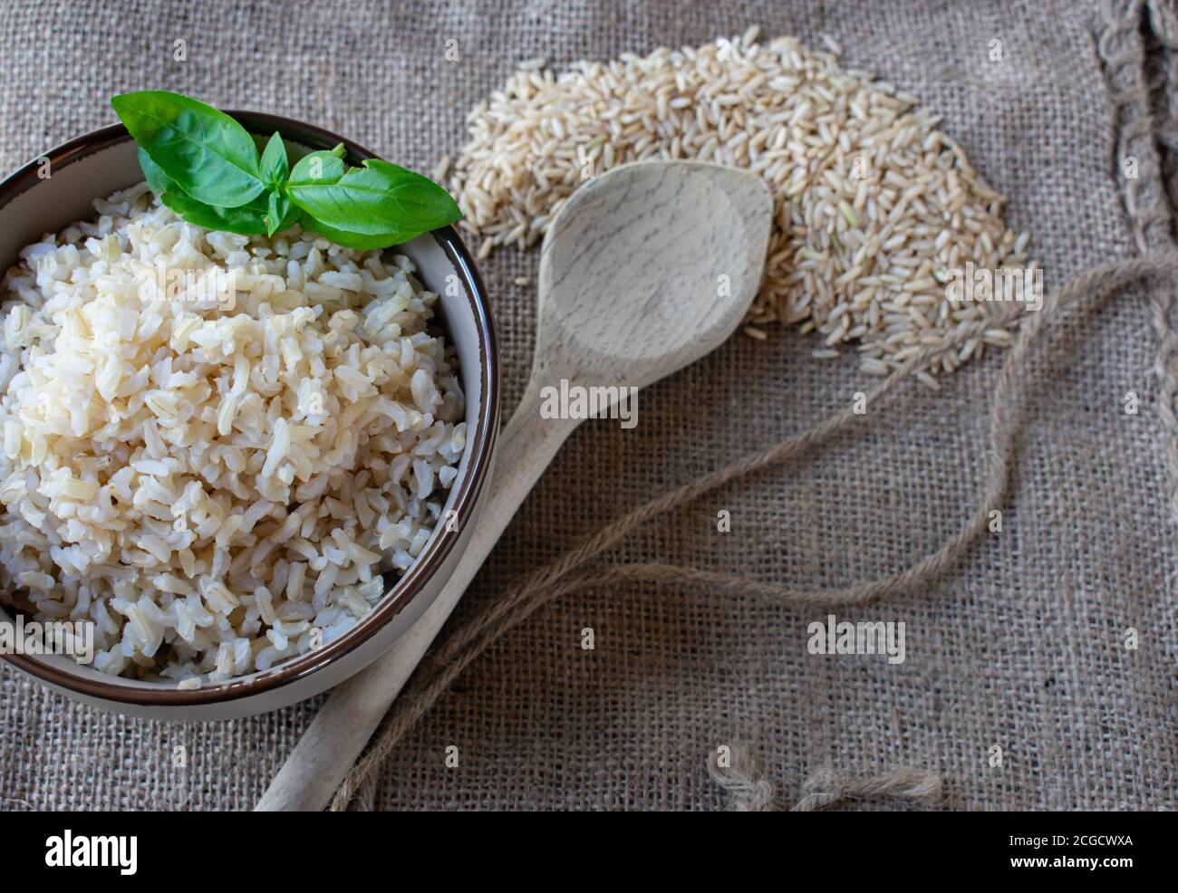 cooked and uncooked brown rice Stock Photo - Alamy