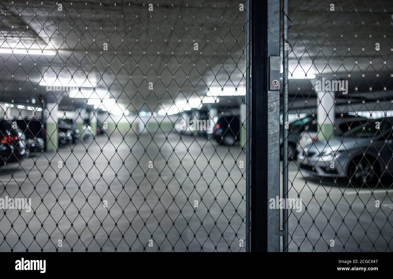 Gated underground parking. Cars parked in a garage with no people. Many ...