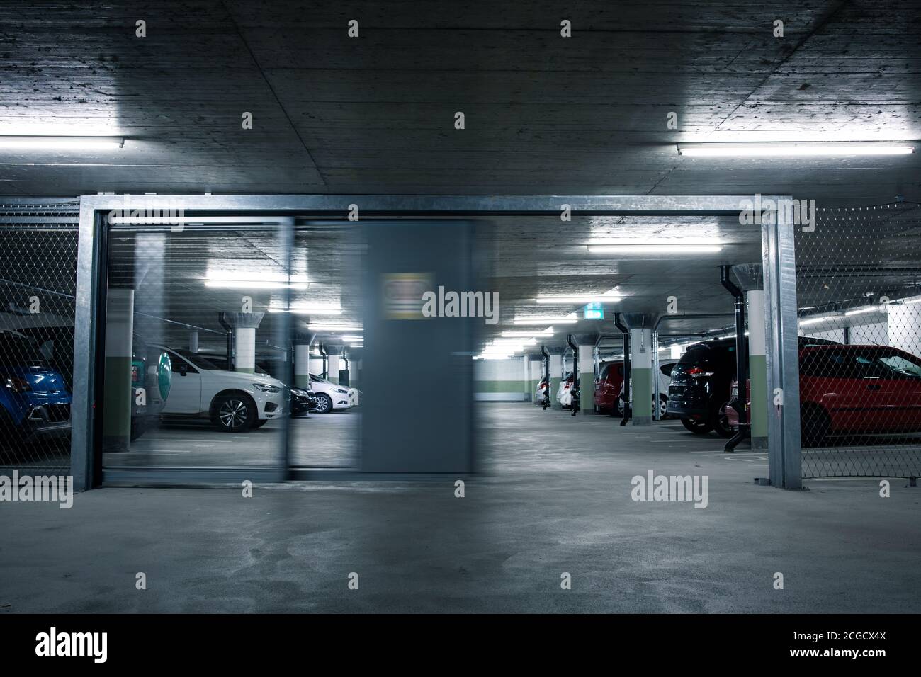 Gated underground parking. Cars parked in a garage with no people. Many ...