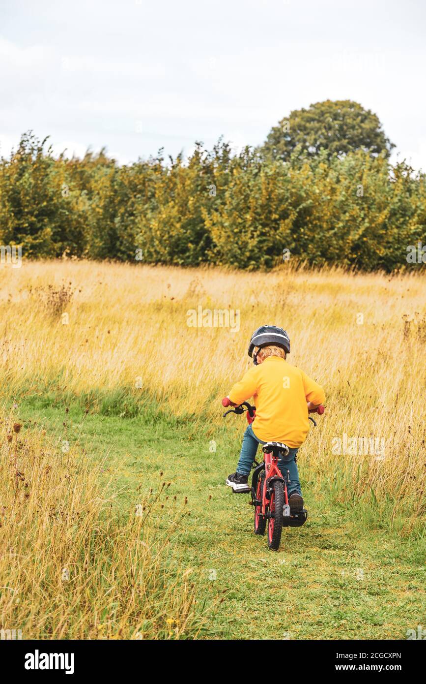 Boy riding through field hi-res stock photography and images - Alamy