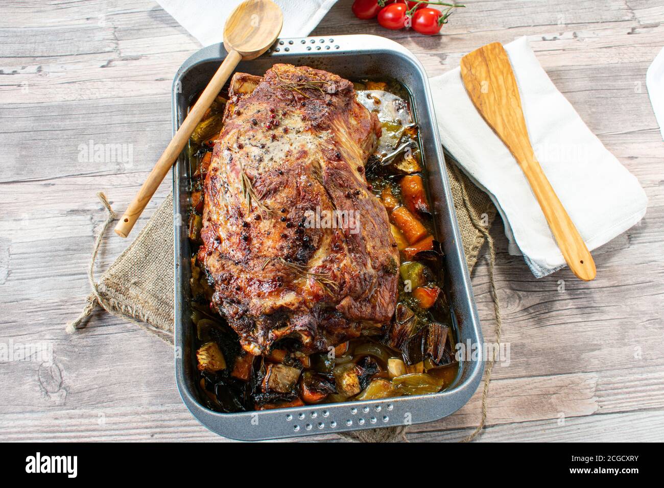 oven baked roast pork - joint of pork on a baking tray with root ...