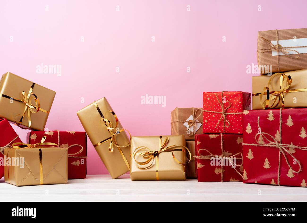 Pile of stacked gift boxes against pink background Stock Photo - Alamy