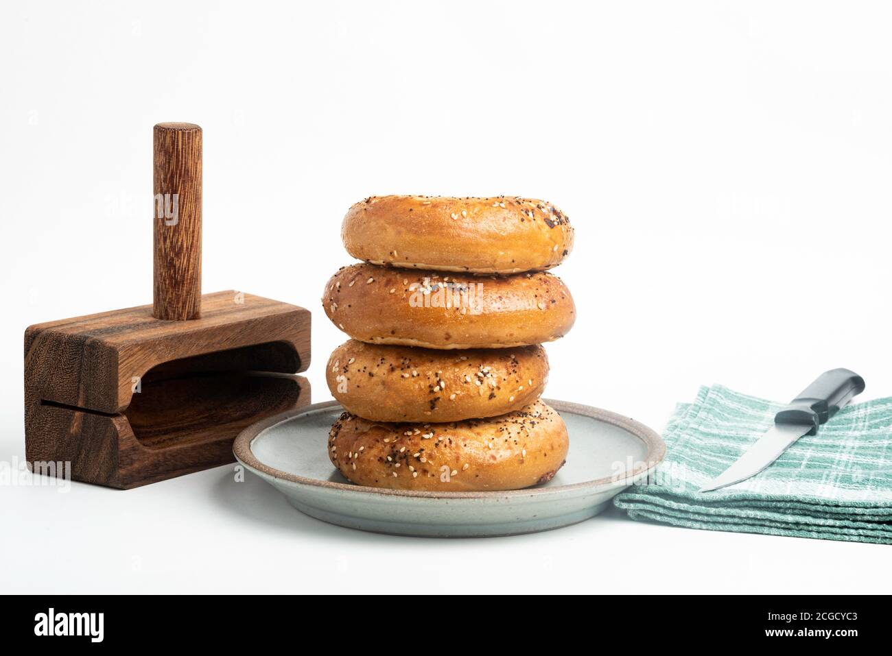 A single tall stack of four freshly baked bagels on a ceramic plate ...