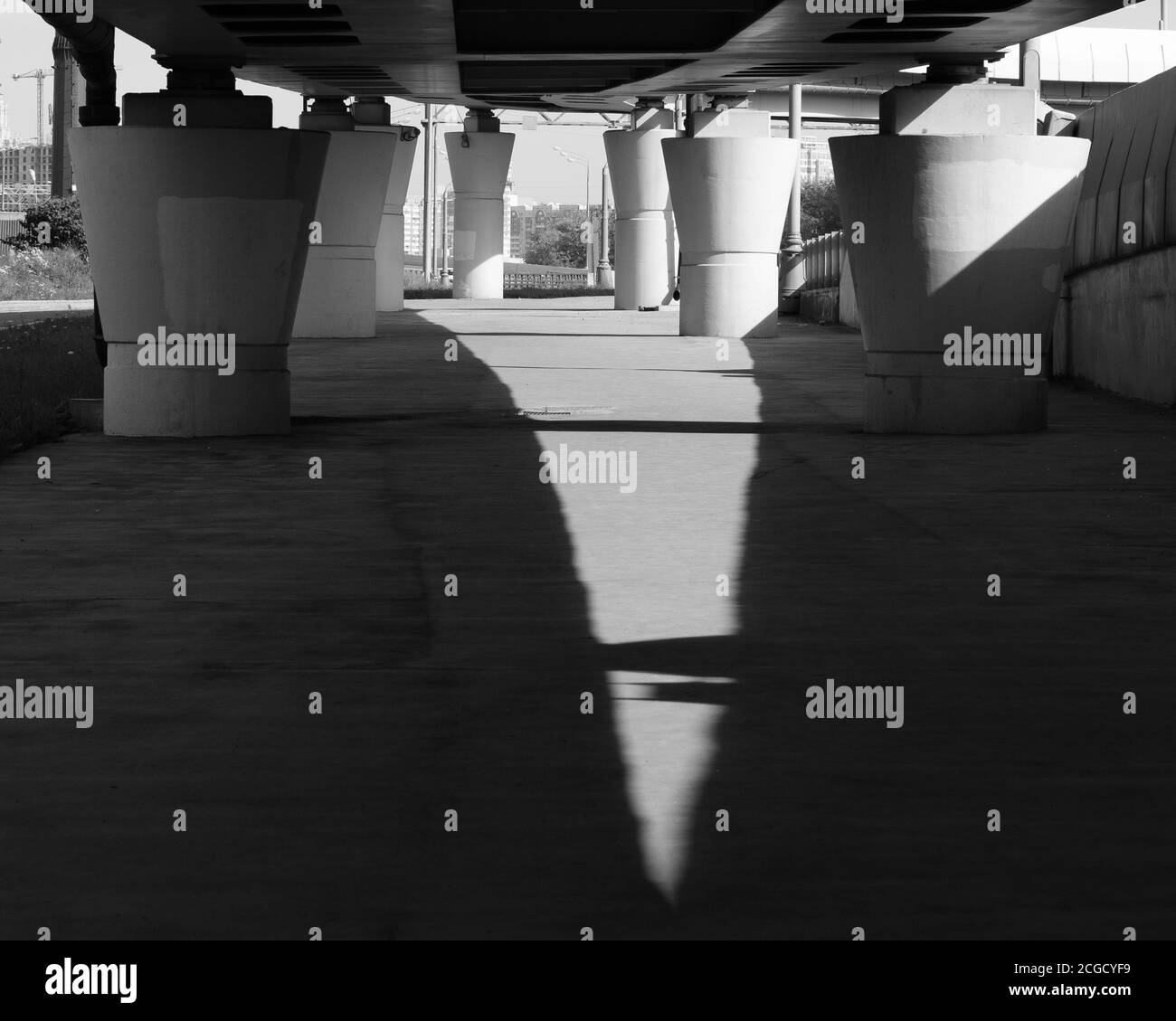 Black and white image of concrete supports under a road bridge ...