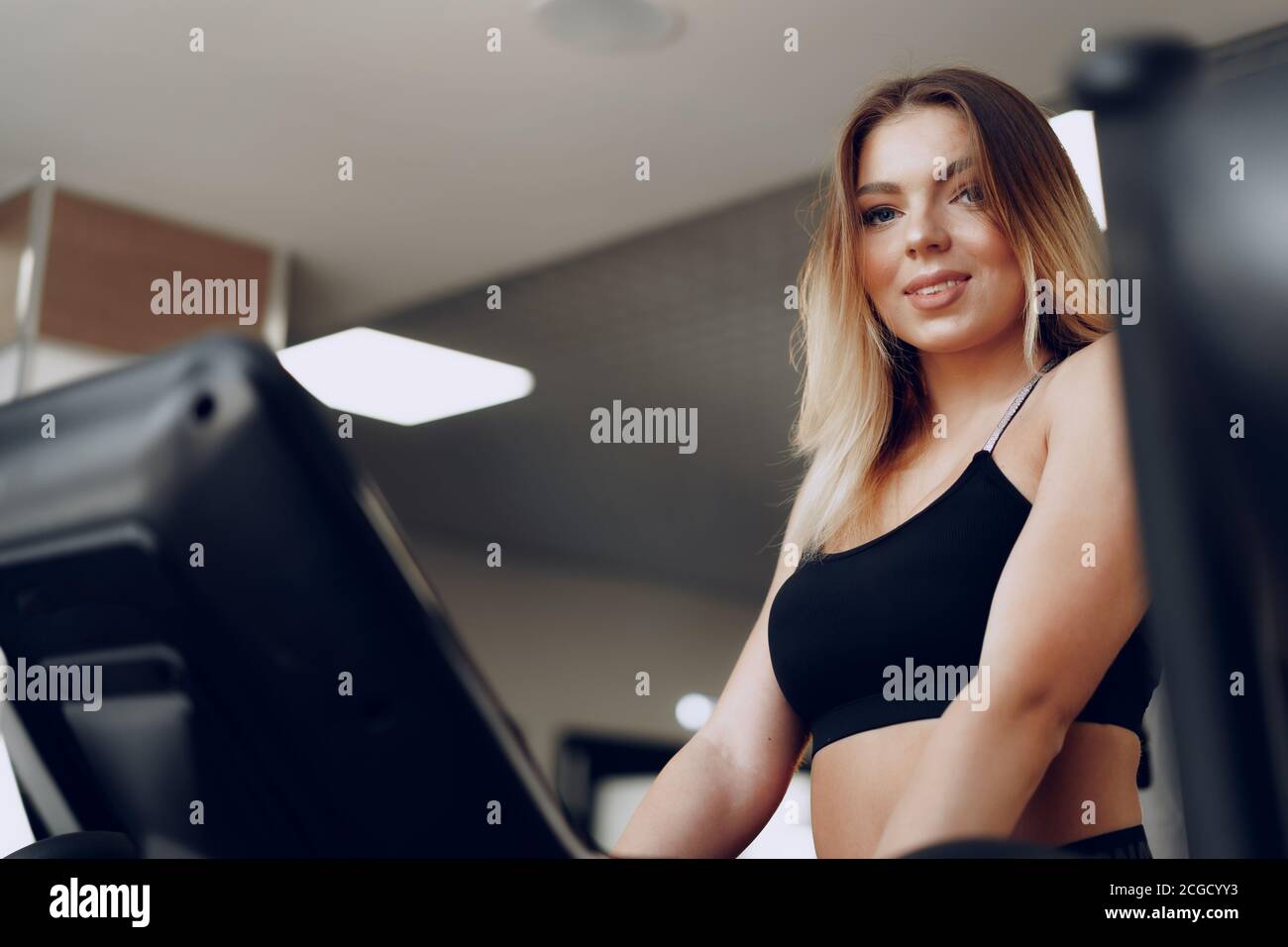 Fit curvy young blonde woman training in a cardio zone in a gym Stock Photo - Alamy