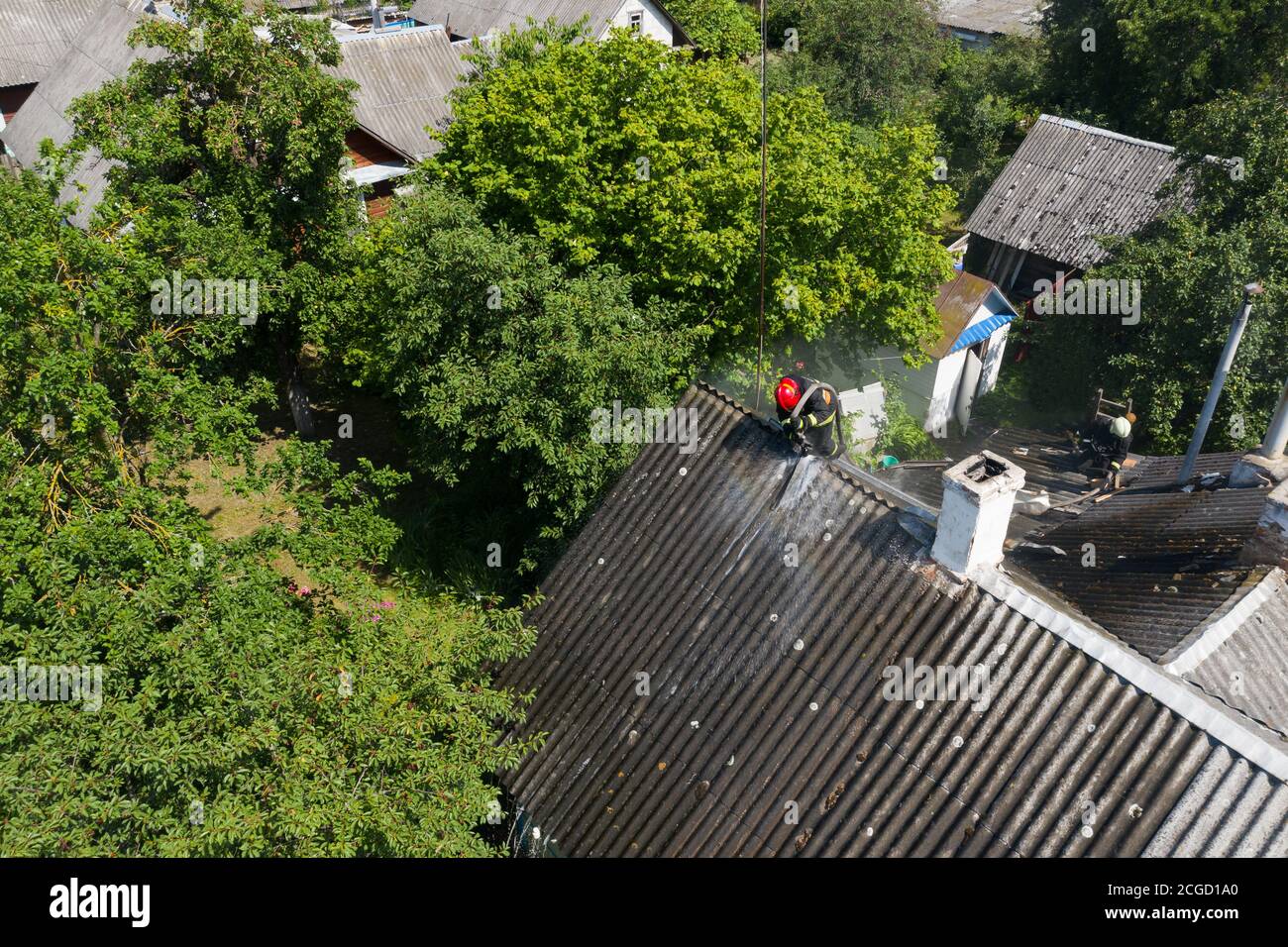 firefighter on the roof extinguishes the fire view from above Stock ...