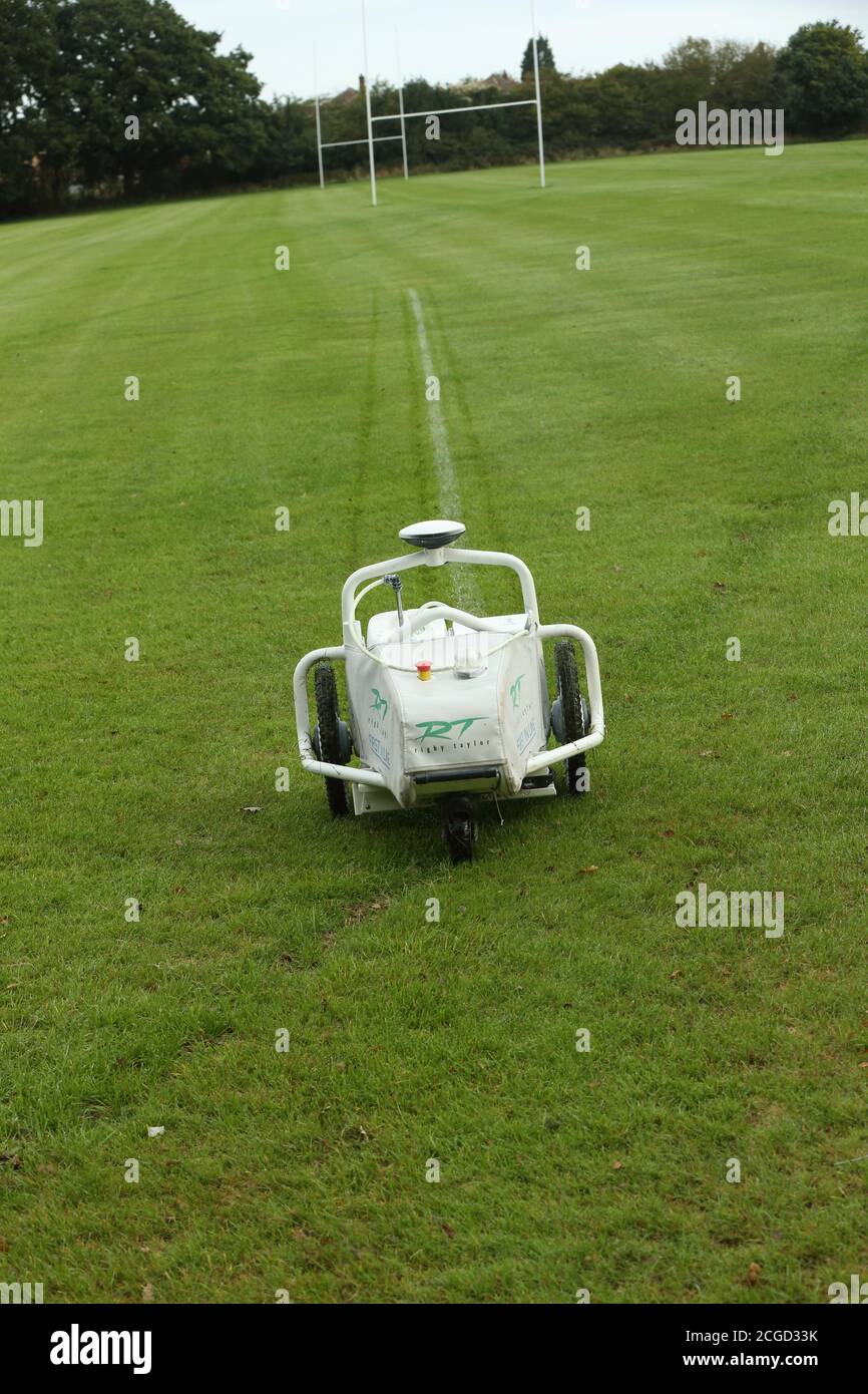 Robotic automatic white line painting machine operating on grass in a ...