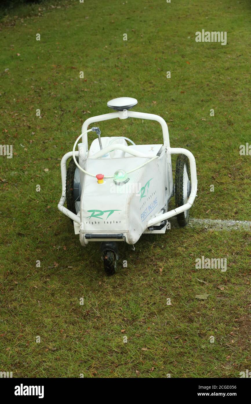 Robotic automatic white line painting machine operating on grass in a ...