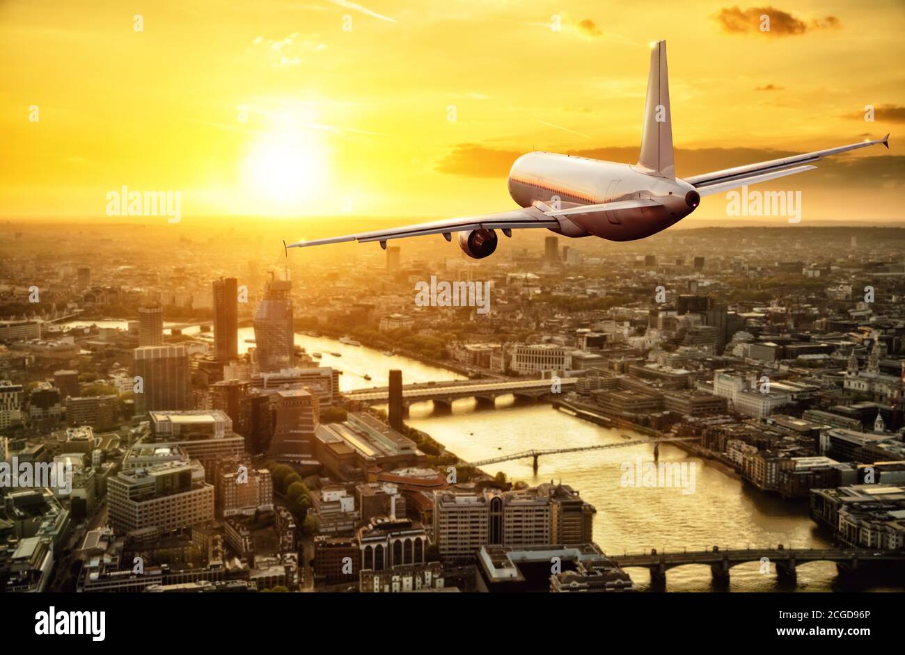 Passengers airplane flying above London city in the sunset light ...