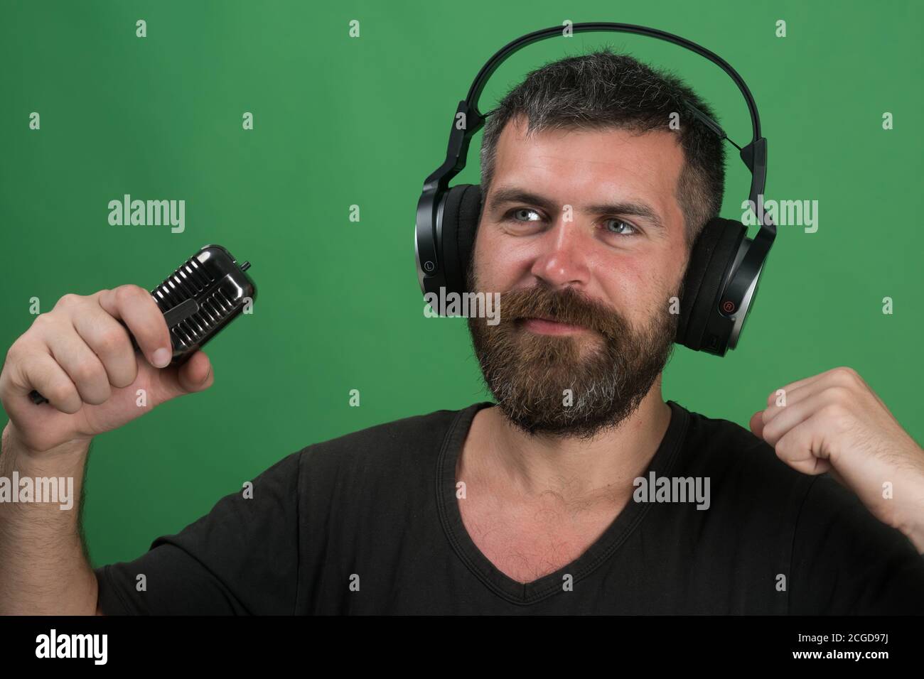 Man holds microphone on green background. Relax and music concept ...