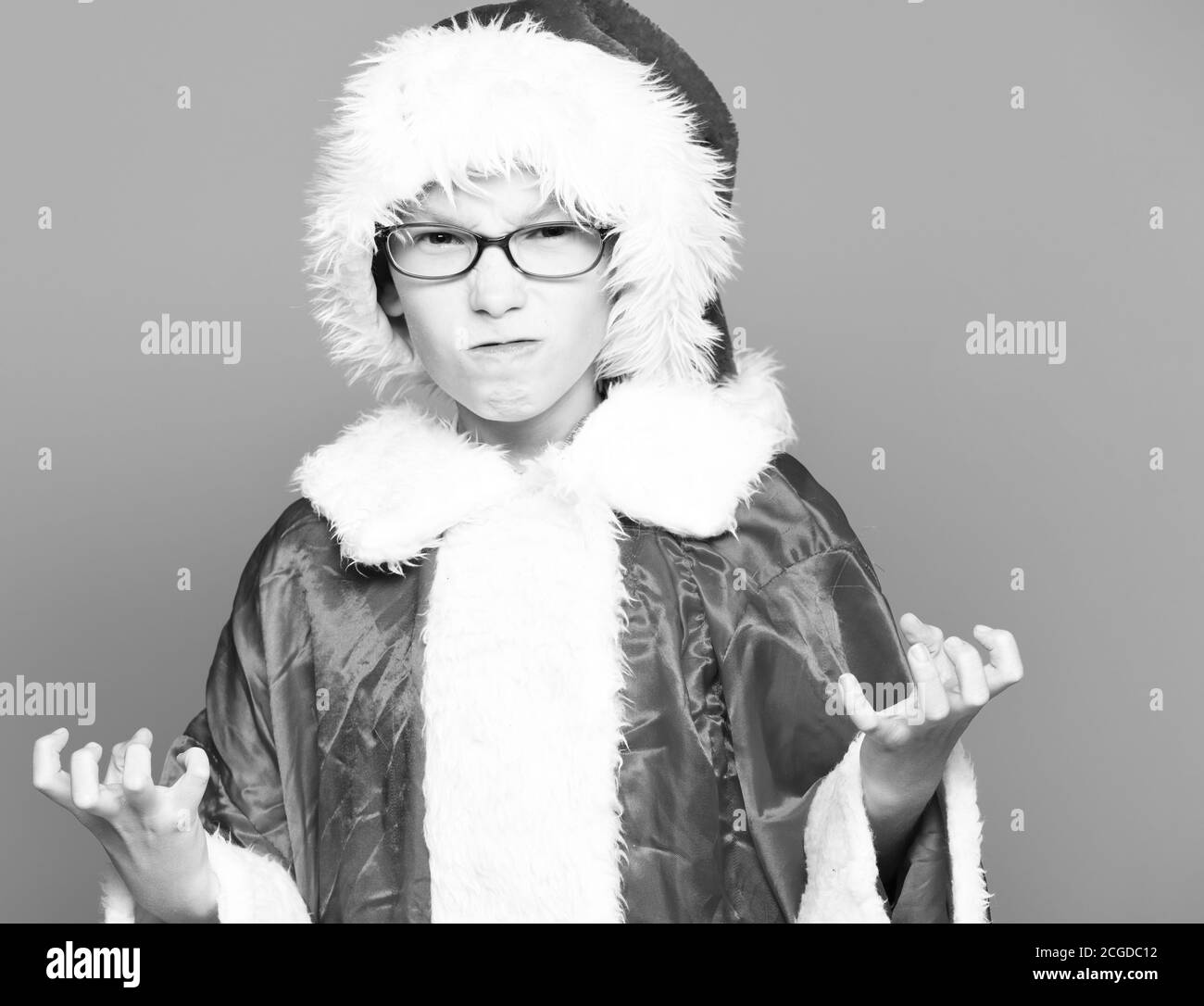 young cute santa claus boy with glasses in red sweater and new year hat ...