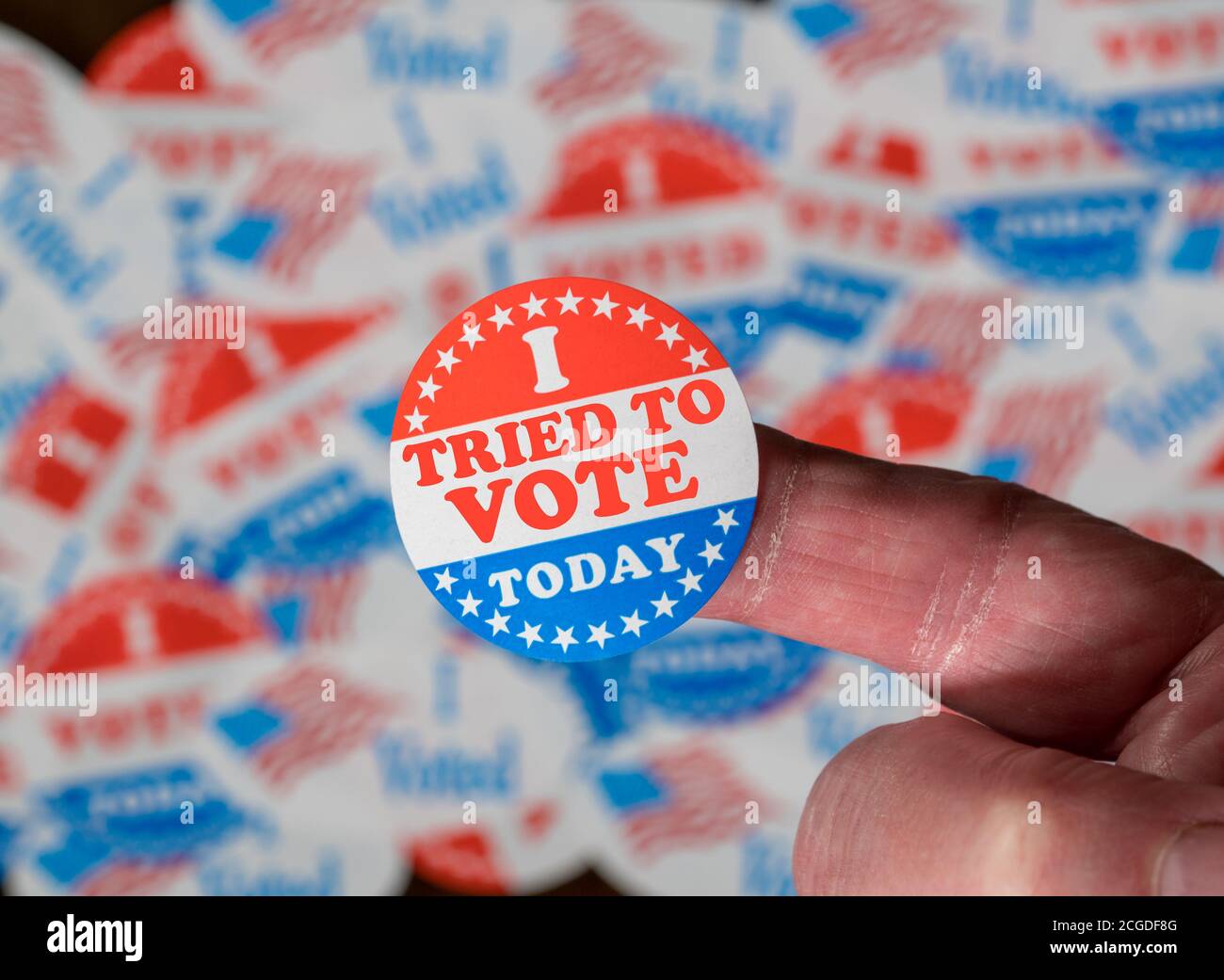 Finger with I Voted button in front of voting stickers given to US ...