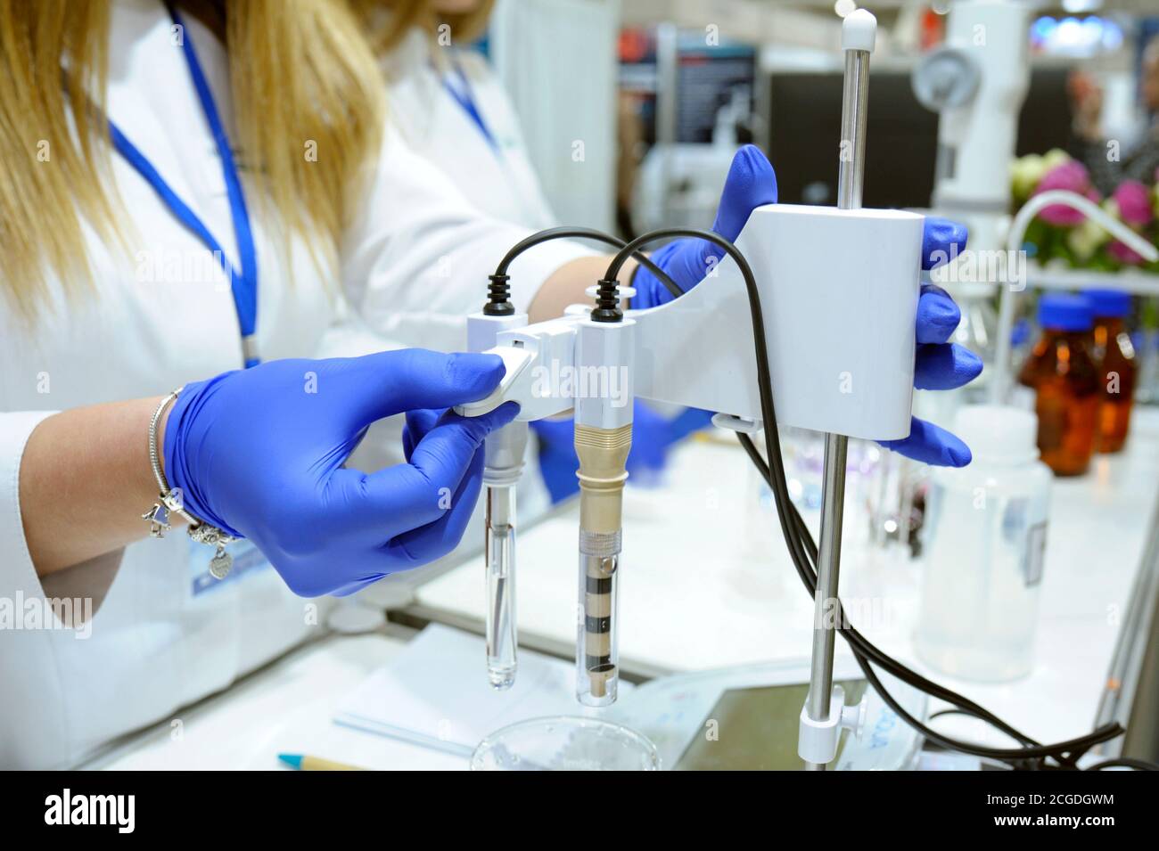 Lab assistant hands in blue gloves adjusting the ionometer to measure ...
