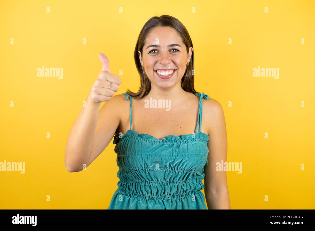 Young beautiful woman over isolated yellow background smiling and doing ...