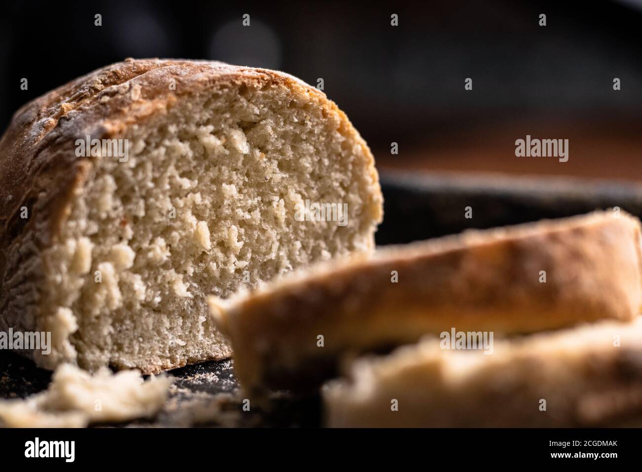 Baked homemade bread on black and wooden background, bakery setting ...