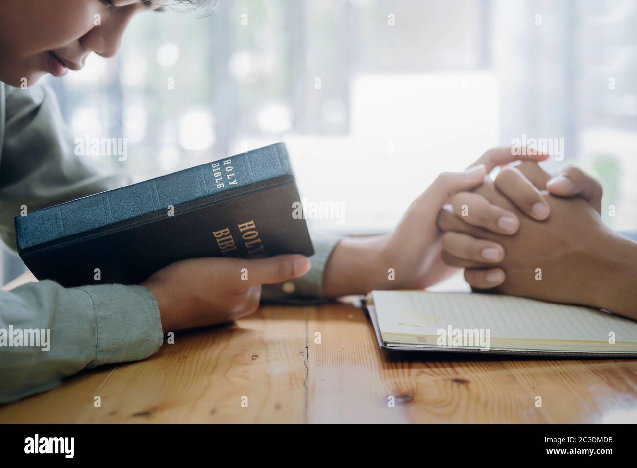 Two christian people are praying together over holy bible Stock Photo ...