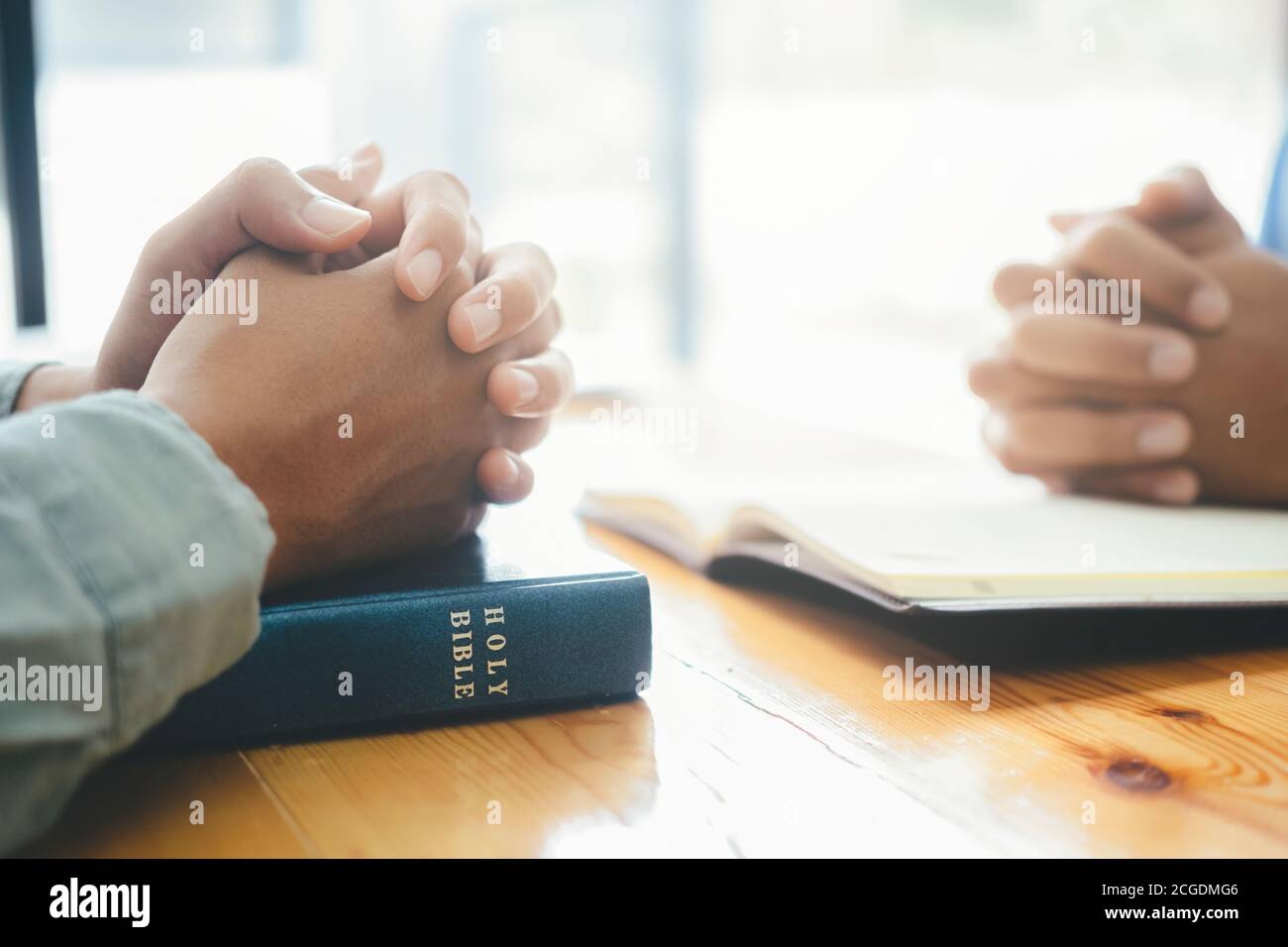 Two christian people are praying together over holy bible Stock Photo ...