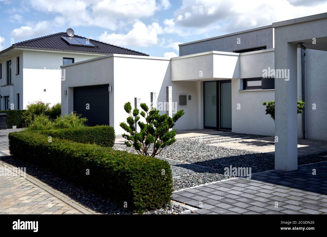 a modern white house with easy care garden without pest plants, view ...