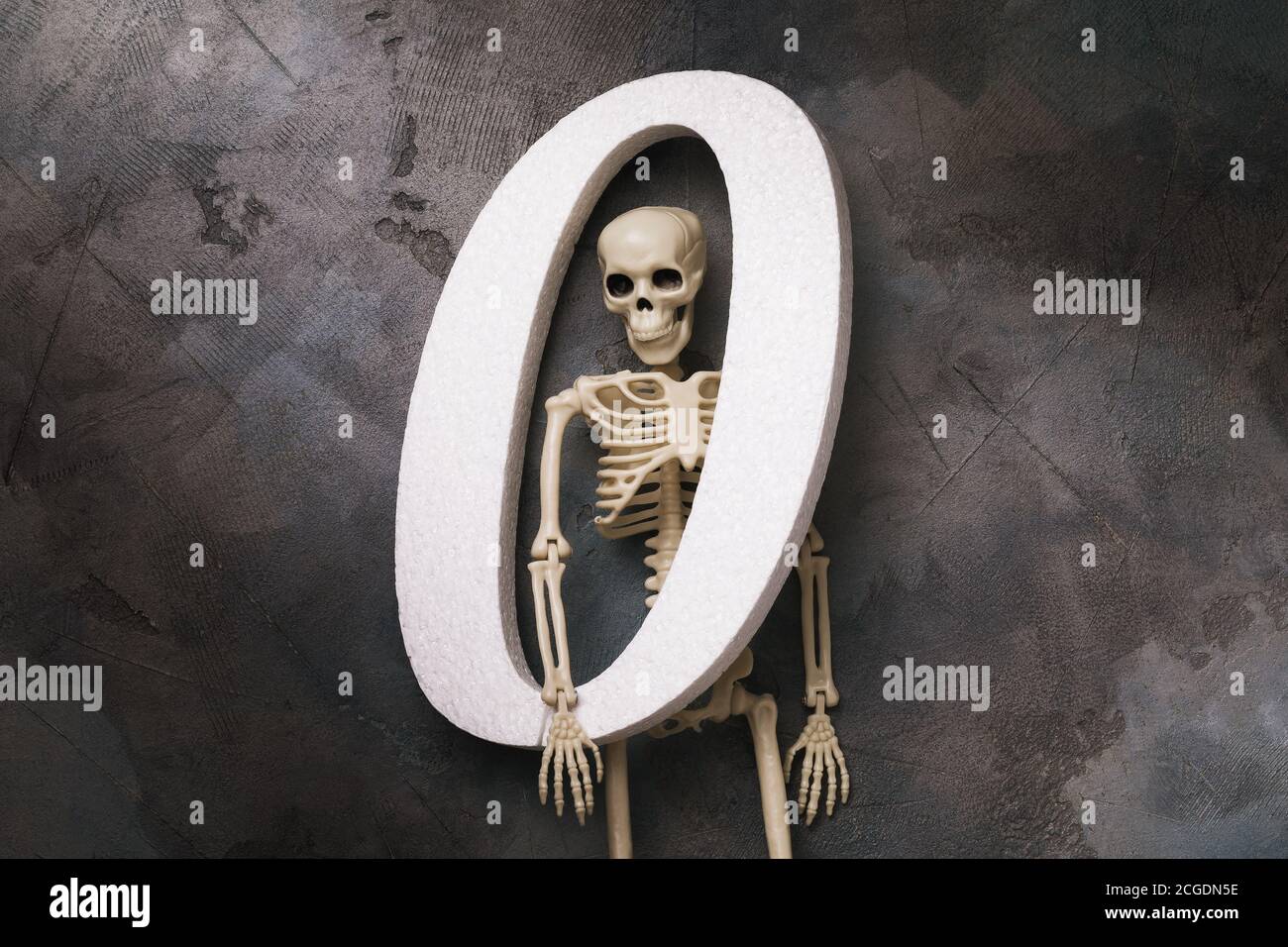 Human skeleton and number zero on a dark background, top view. Zeroing ...