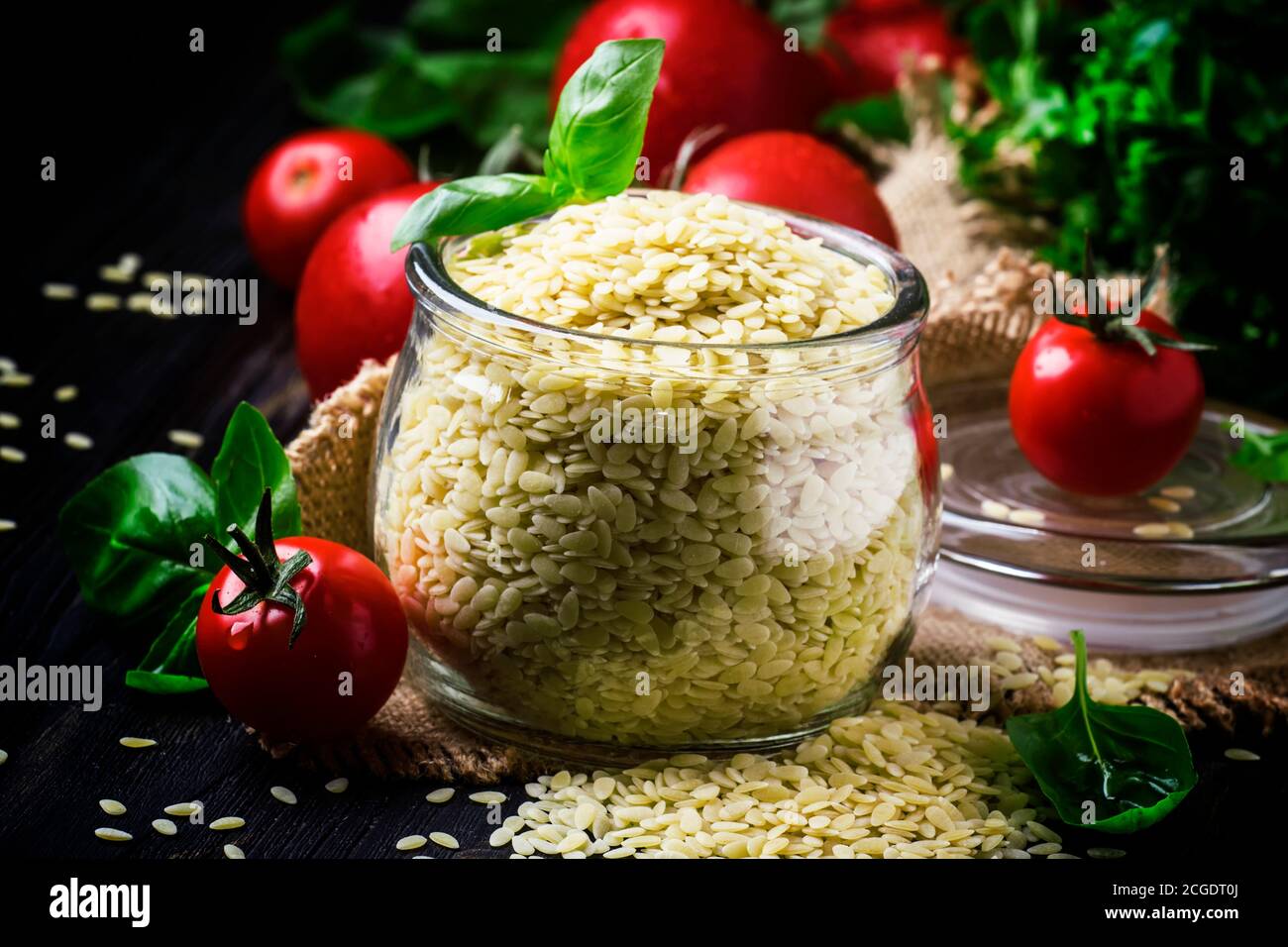Italian pasta orzo in the form of rice in glass jar, selective focus ...