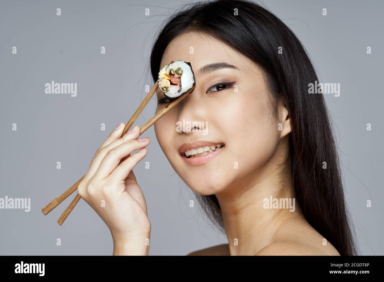 beautiful woman with wooden chopsticks in hands and sushi rolls Stock ...