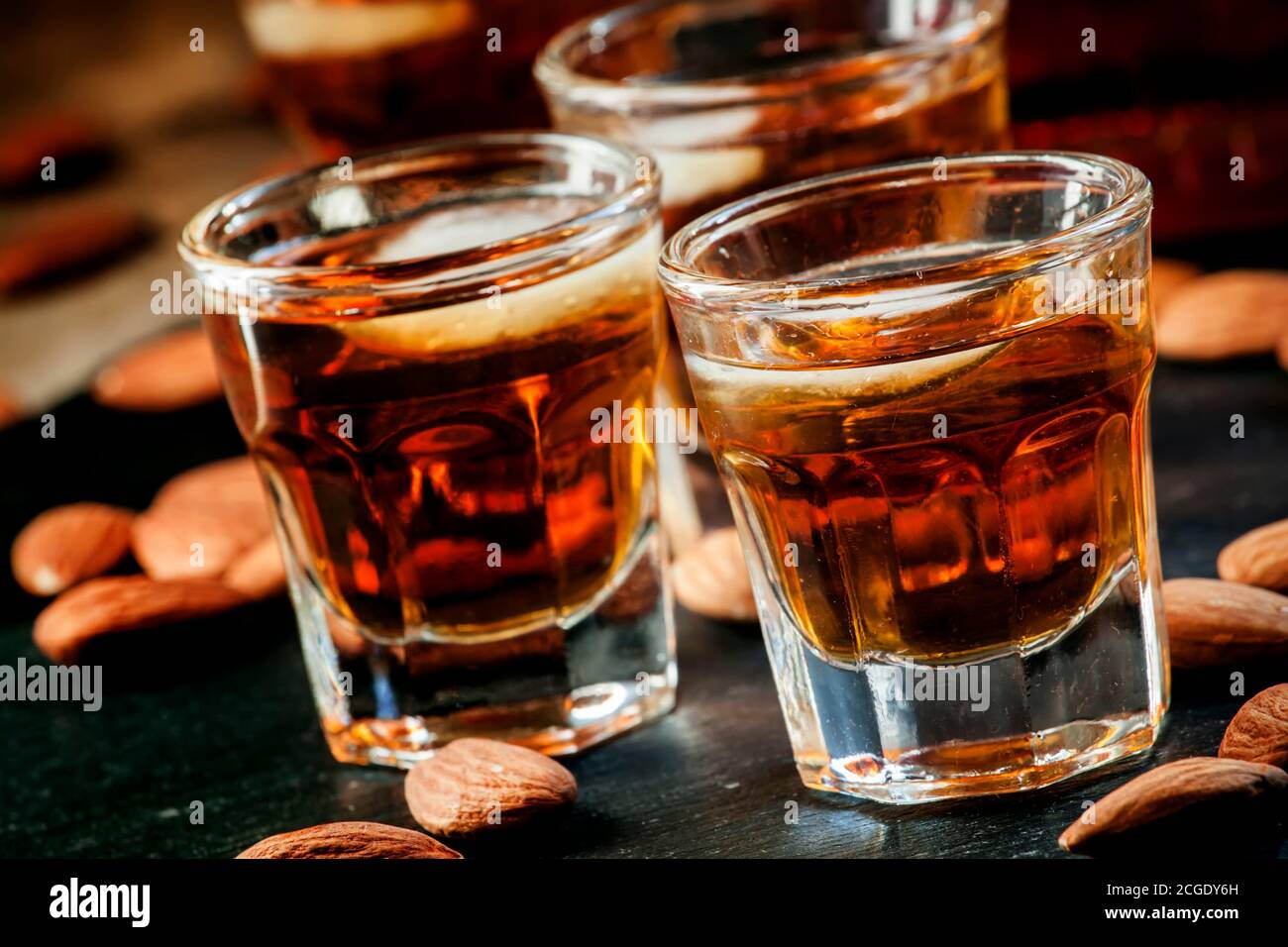 Cold whiskey with ice in a glass and a snack almonds, selective focus ...