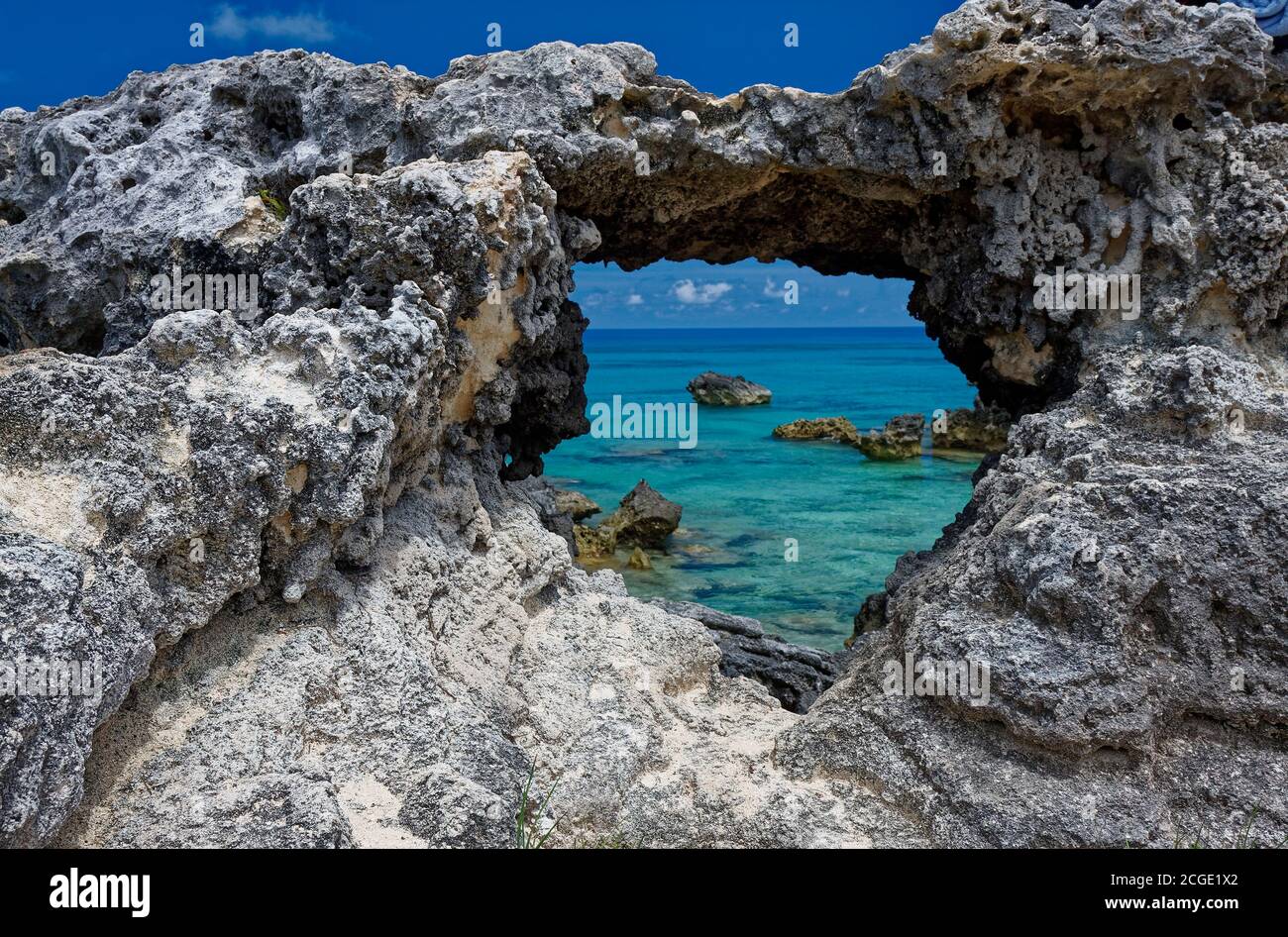 Tobacco Bay, clear aqua water, view through volcanic rock formation ...