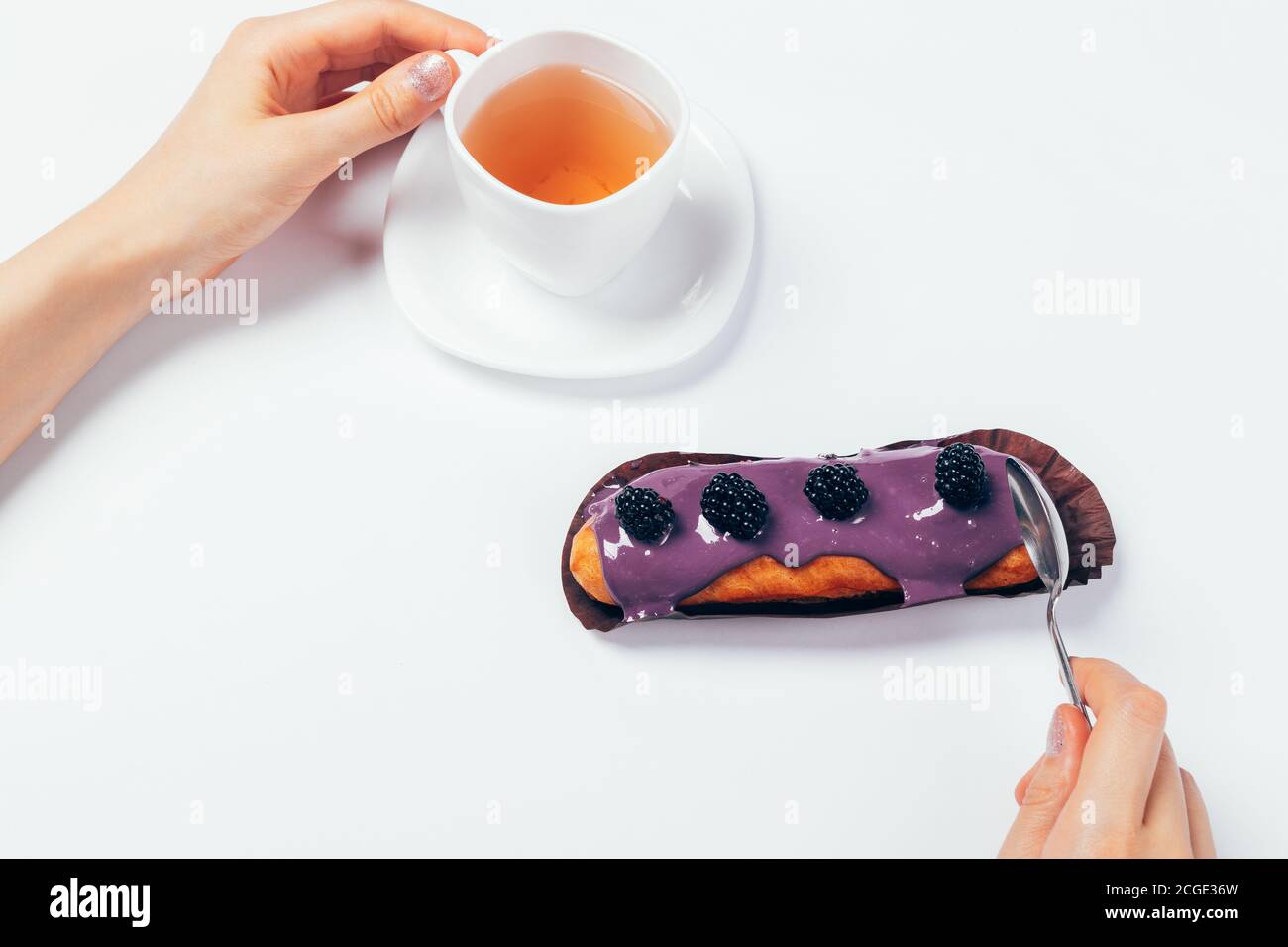 Woman eating cake and drinking tea, top view Stock Photo - Alamy