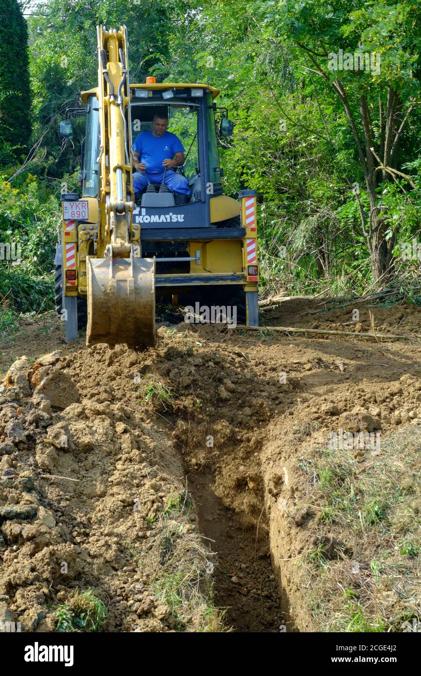 heavy plant digger digging trench in preparation for the laying of new ...