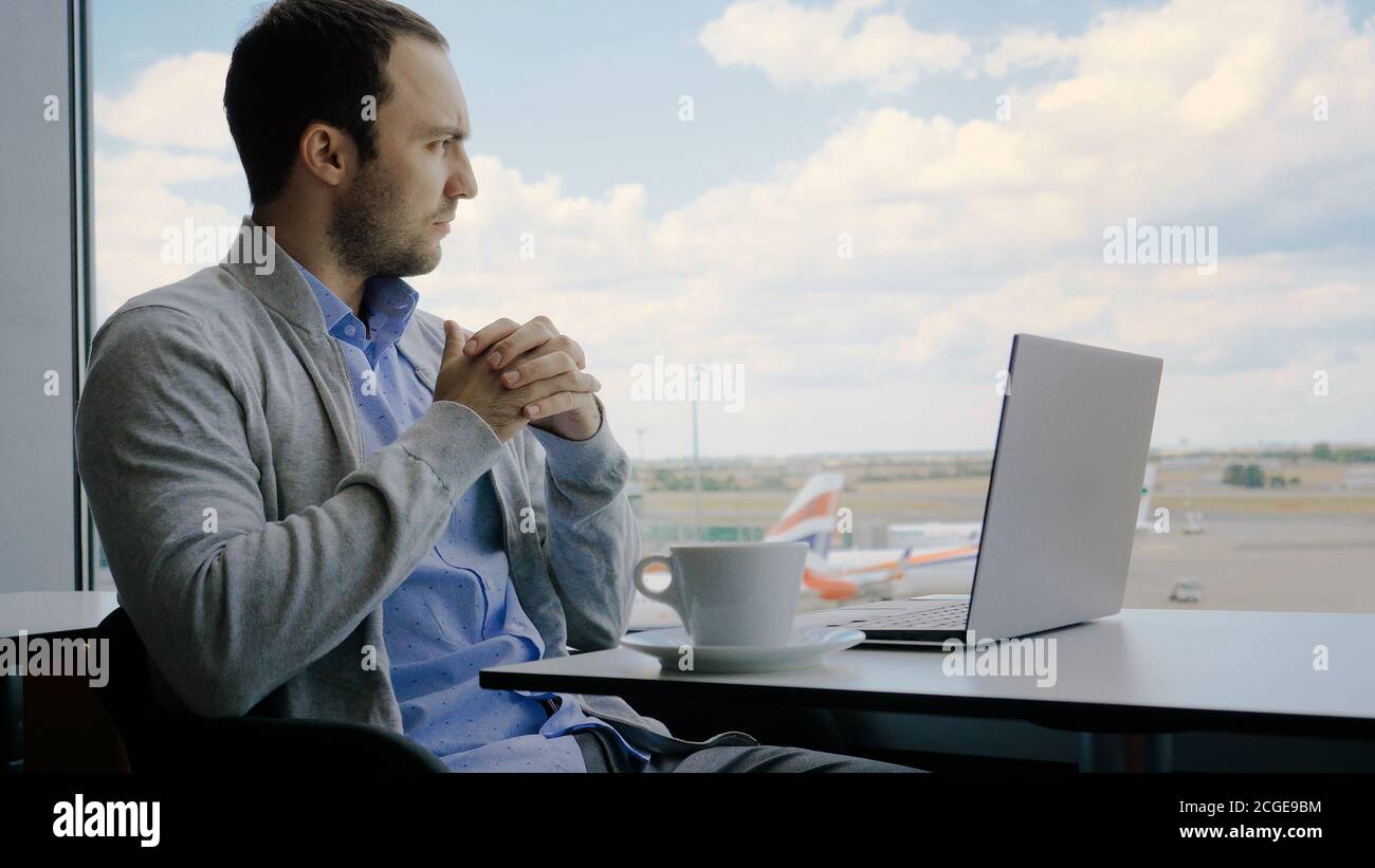 Man thinking while waiting for his flight in the international a Stock ...