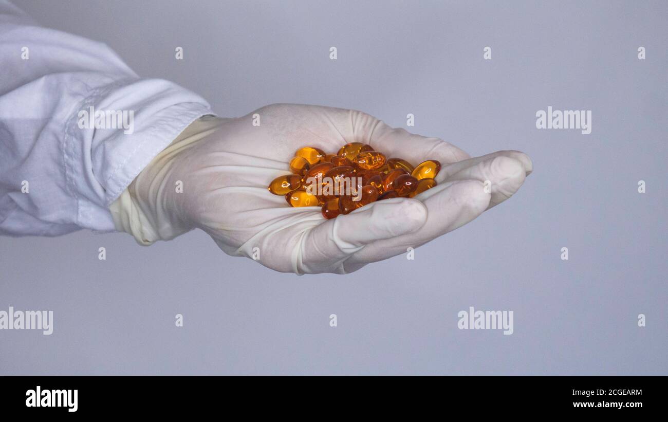 Hand holds omega capsules hi-res stock photography and images - Alamy