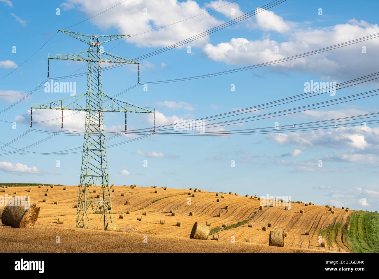 Straw bales on the field near high electricity pylons Stock Photo - Alamy