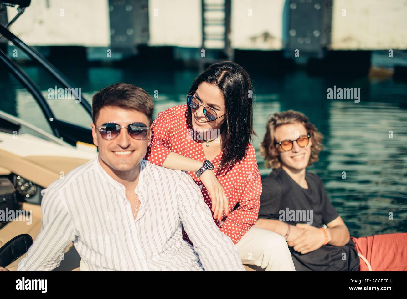 A group of friends chatting on boat deck in city dock while waiting for ...