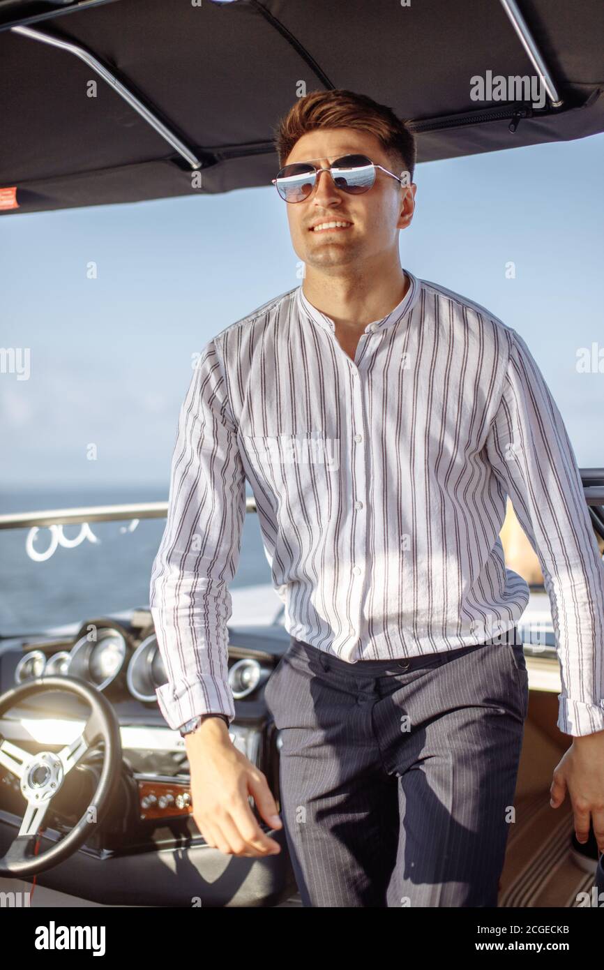 Man driving boat handsome hi-res stock photography and images - Alamy