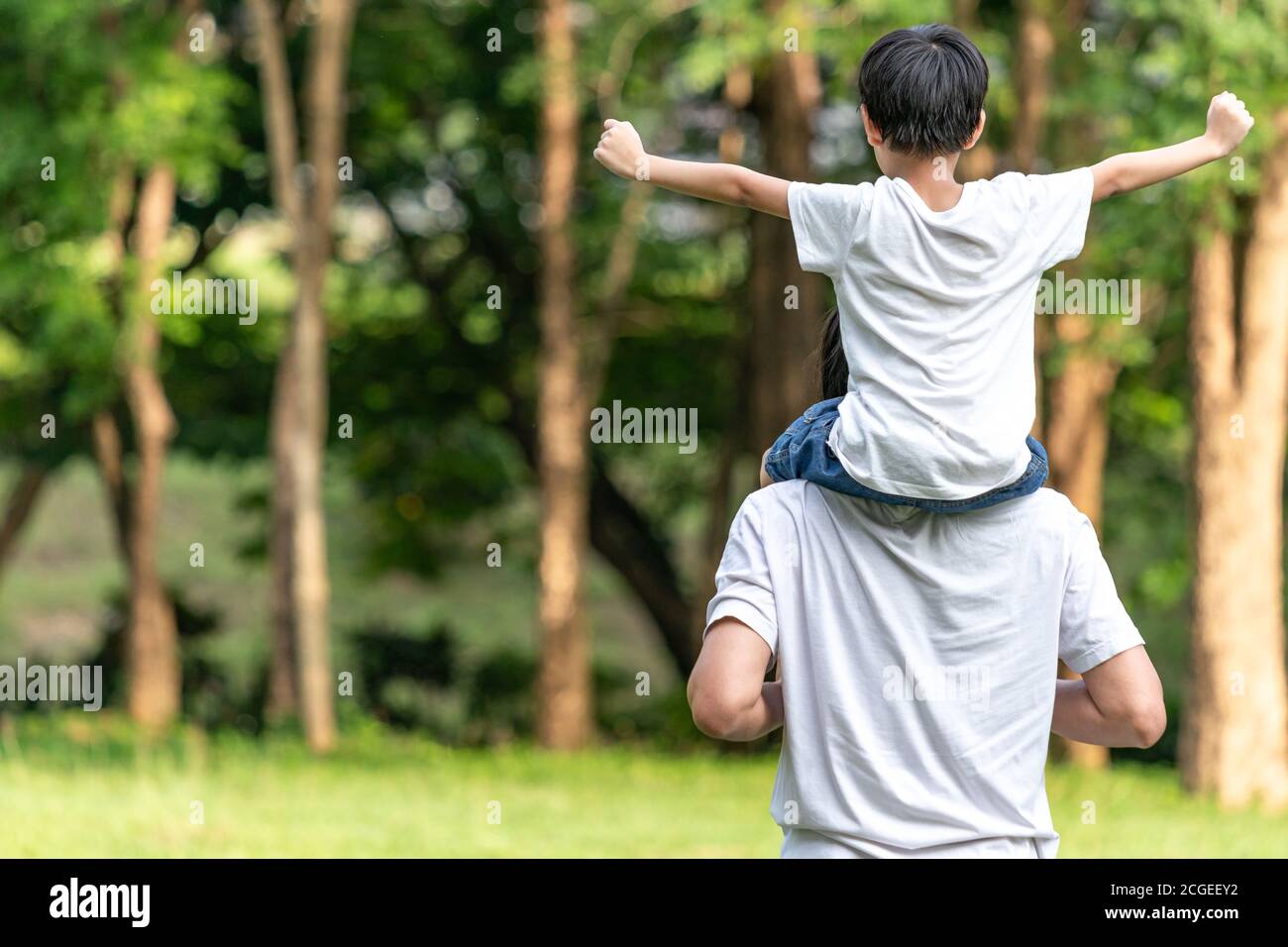 Dad giving son ride on back in the park. Asian family cute and warm ...