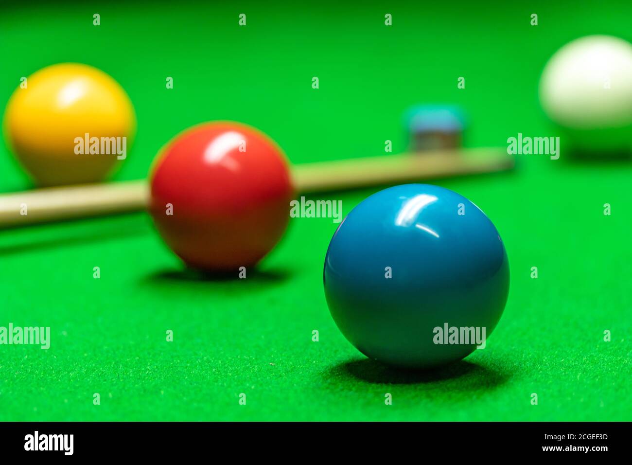 A cue and snooker balls of various colors are placed on the snooker ...